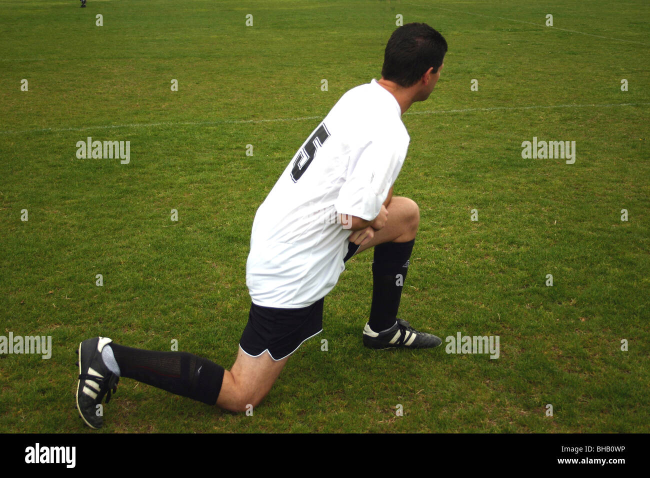 Footballer streteched leg muscles before the start of a game Stock ...