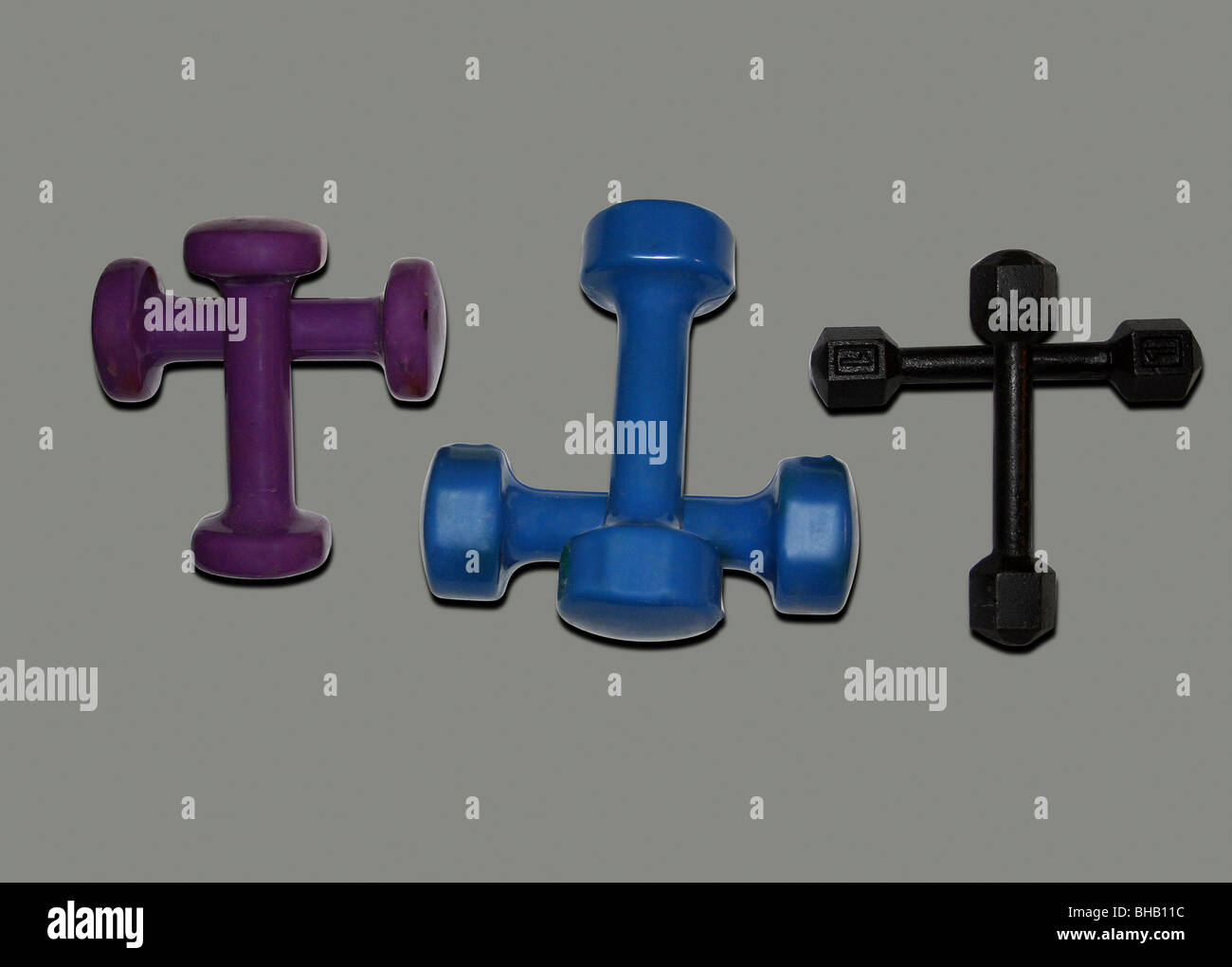 Three sets of crossed free weights on plain background Stock Photo - Alamy