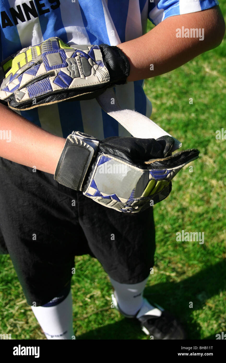 Goalkeeper putting on his football gloves Stock Photo - Alamy