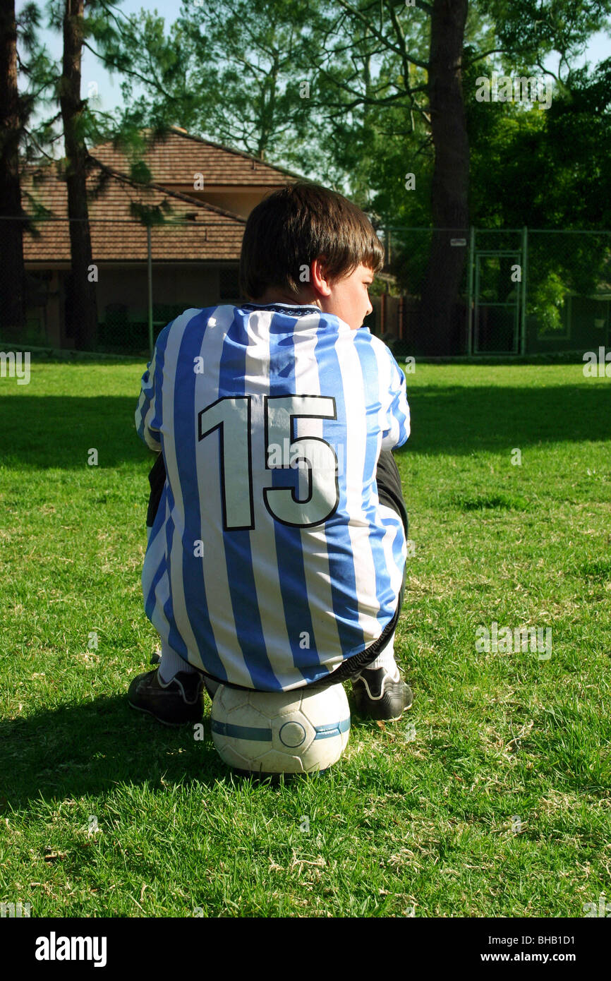 Youth football player takes a time out from practise to sit on a ...