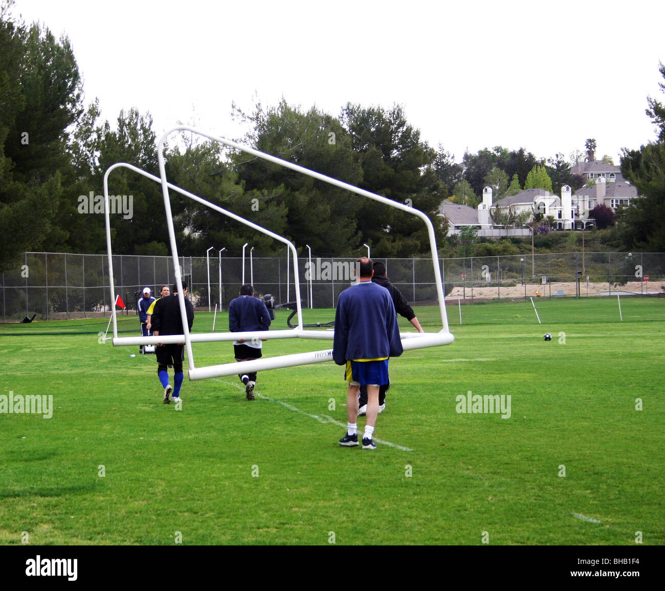 Footballers carrying goal posts before a game Stock Photo - Alamy