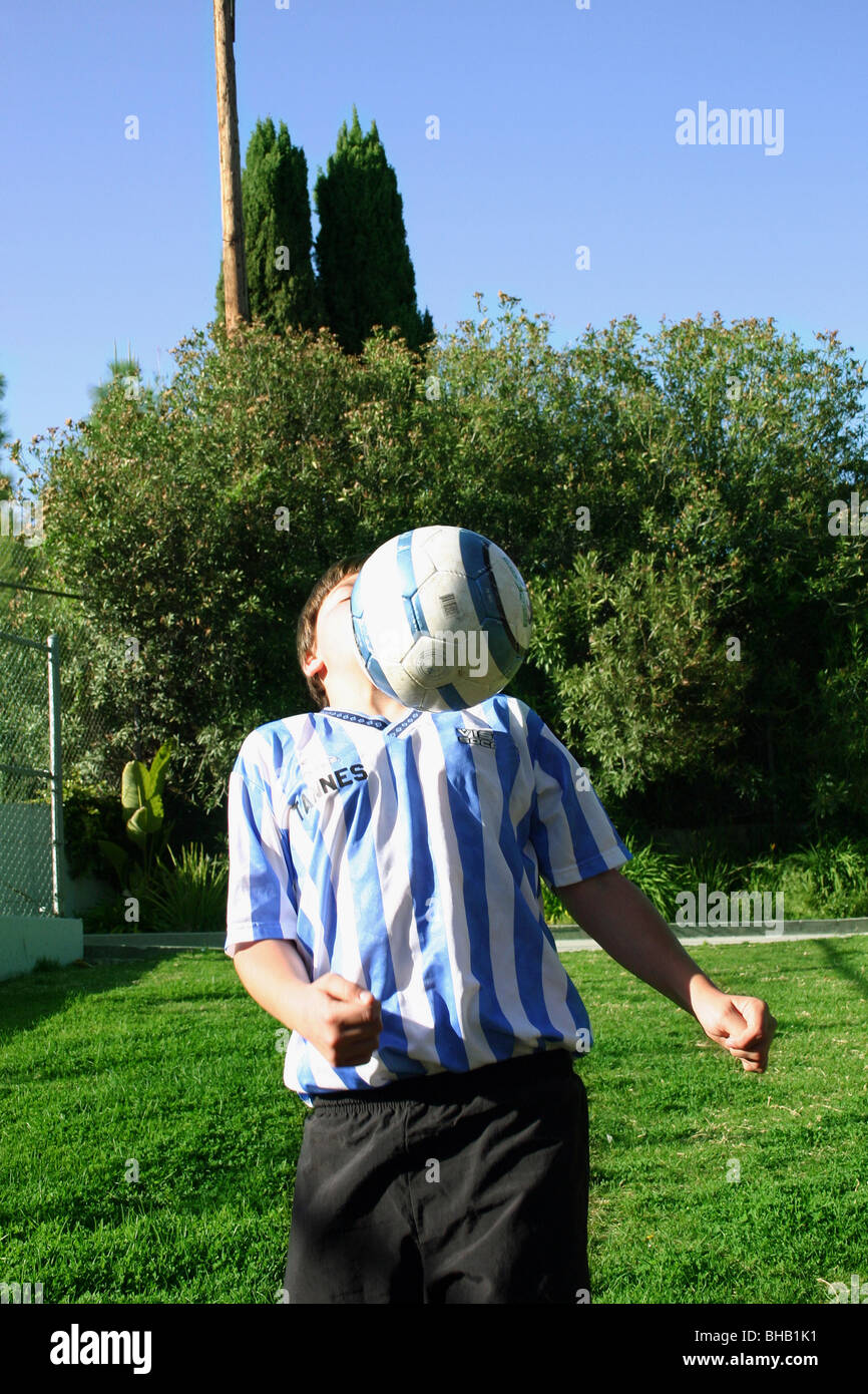 Young football player brings ball under control using chest Stock Photo ...