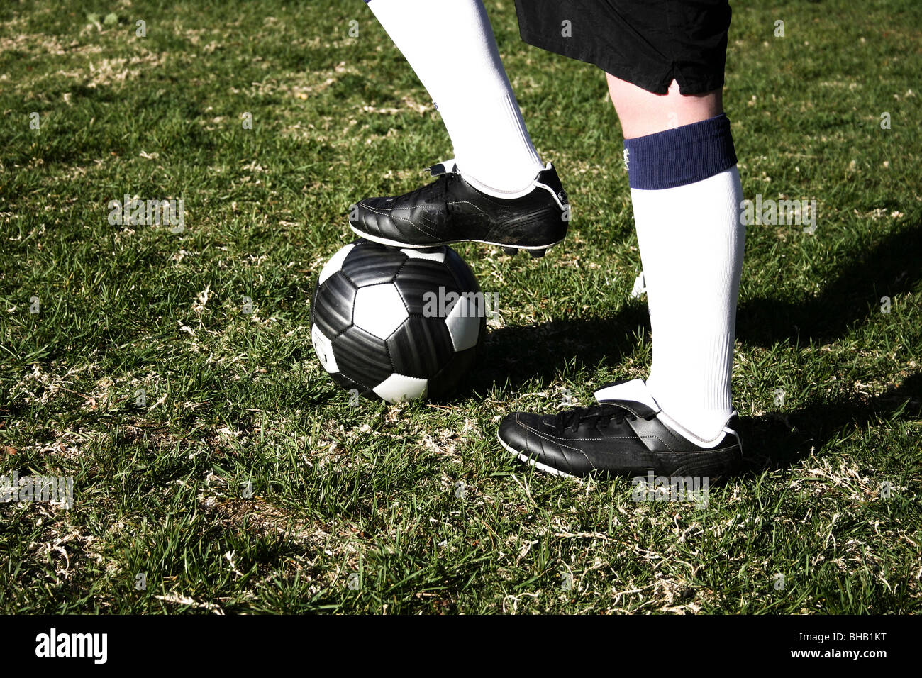 Football player with his foot on top of football Stock Photo - Alamy