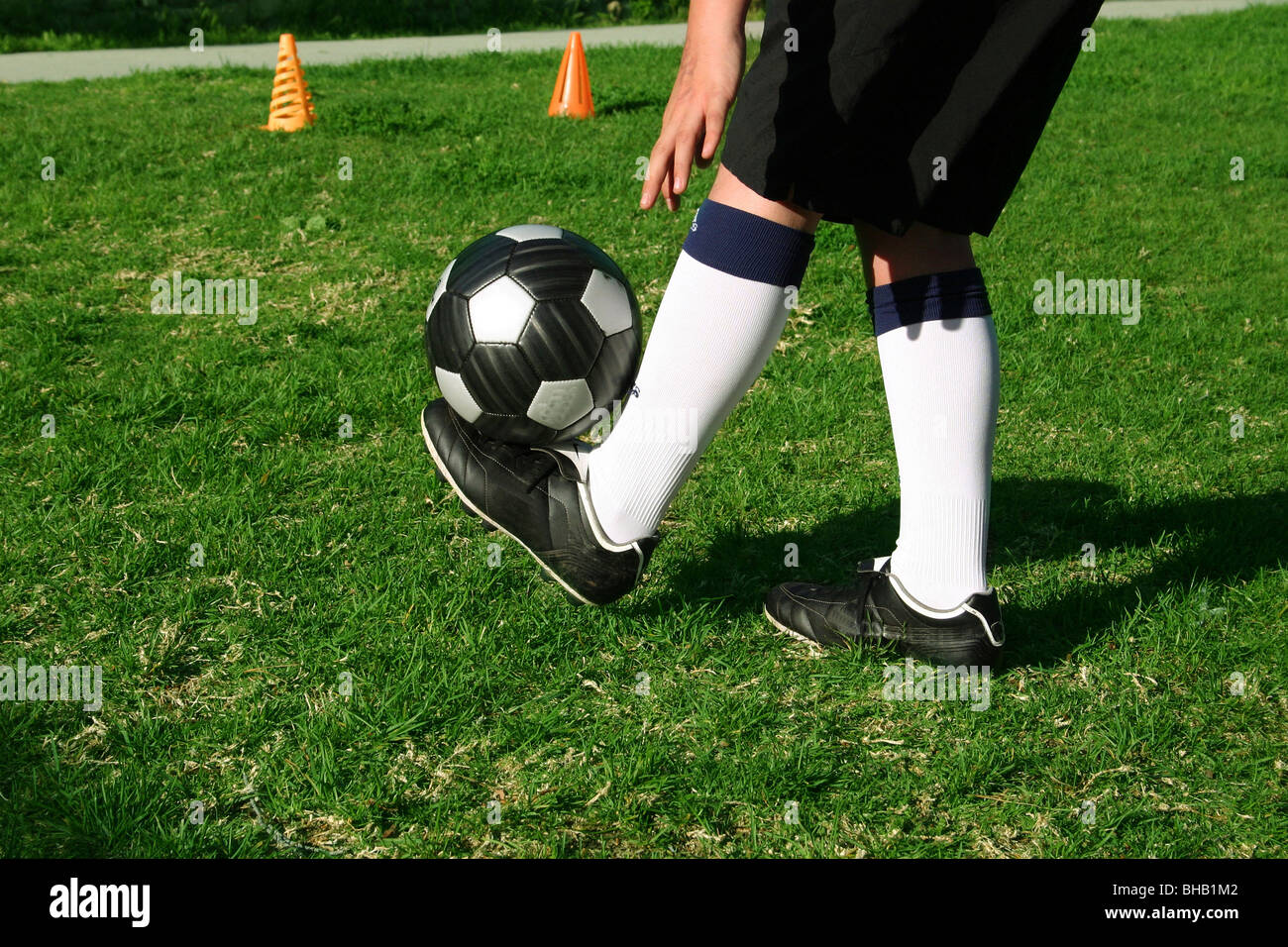Football player practises his skills by balancing football on boot ...