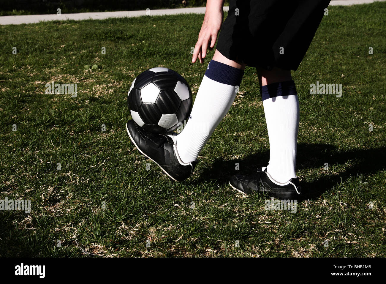Football player practises his skills by balancing football on boot ...