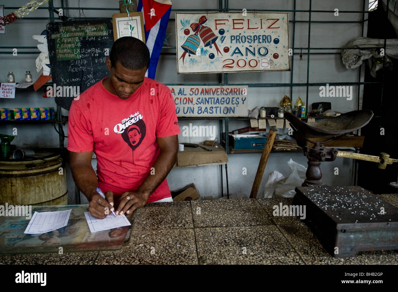 A Cuban shop assistant working in a state shop in Santiago de Cuba ...