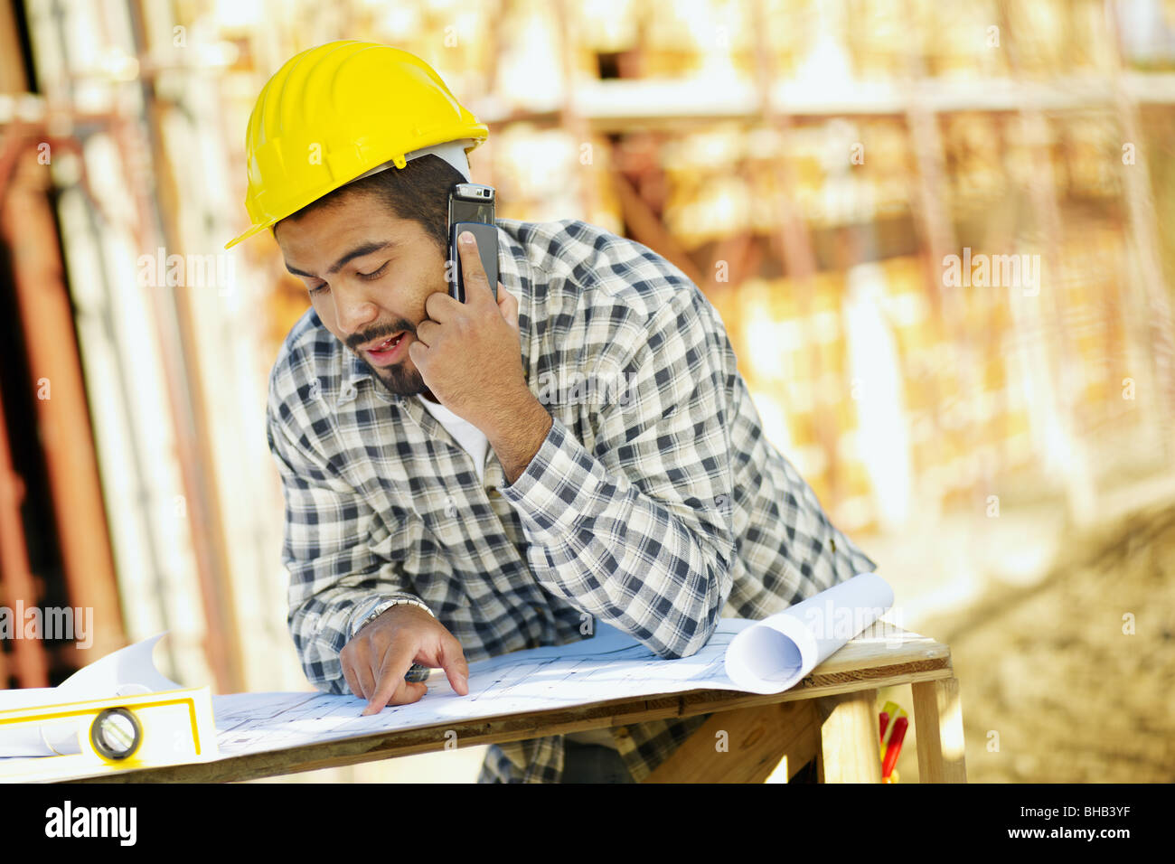 latin american construction worker talking on mobile phone. Copy space ...