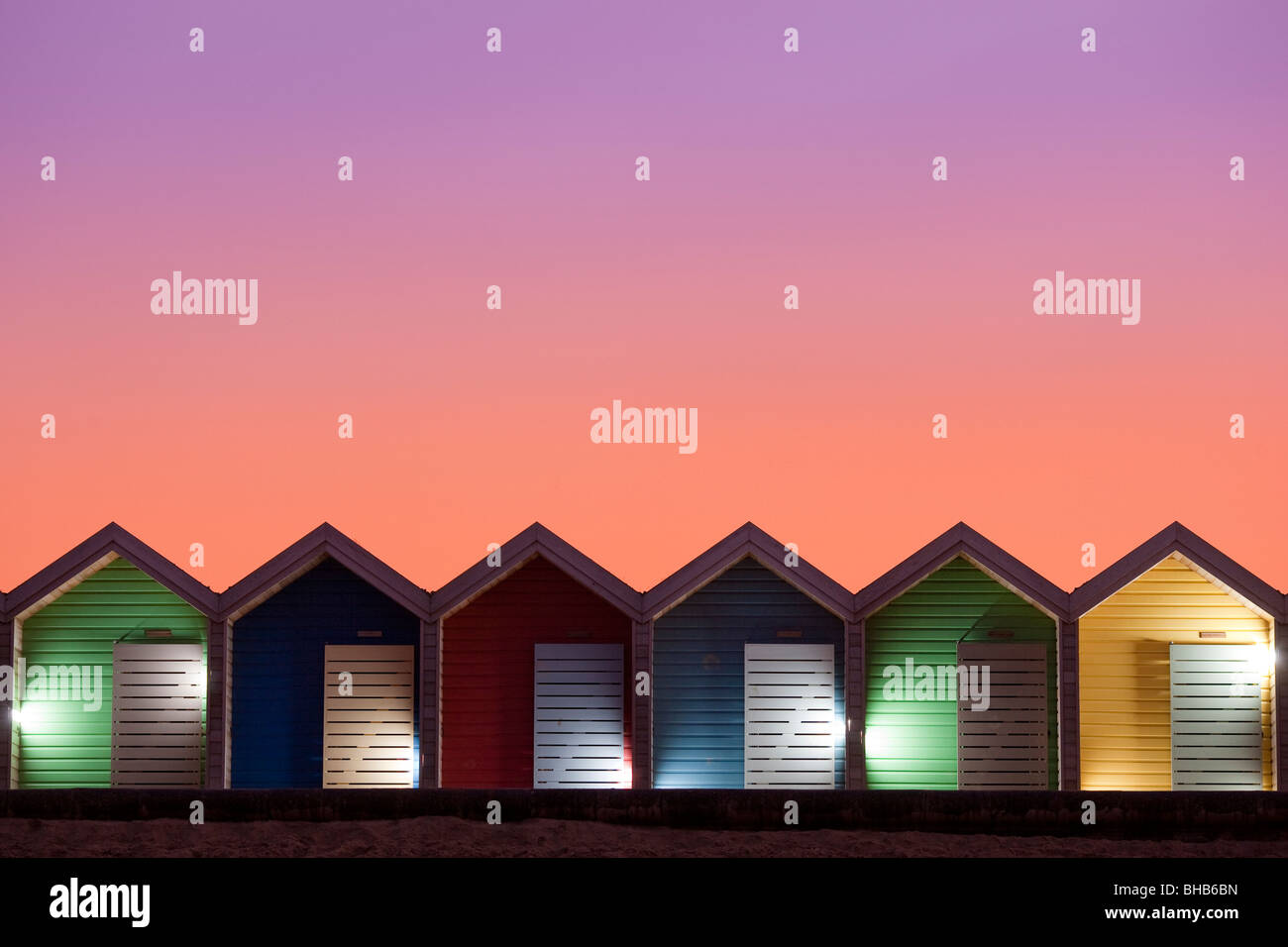 Colourful, illuminated beach huts at sunset on Blyth Beach ...