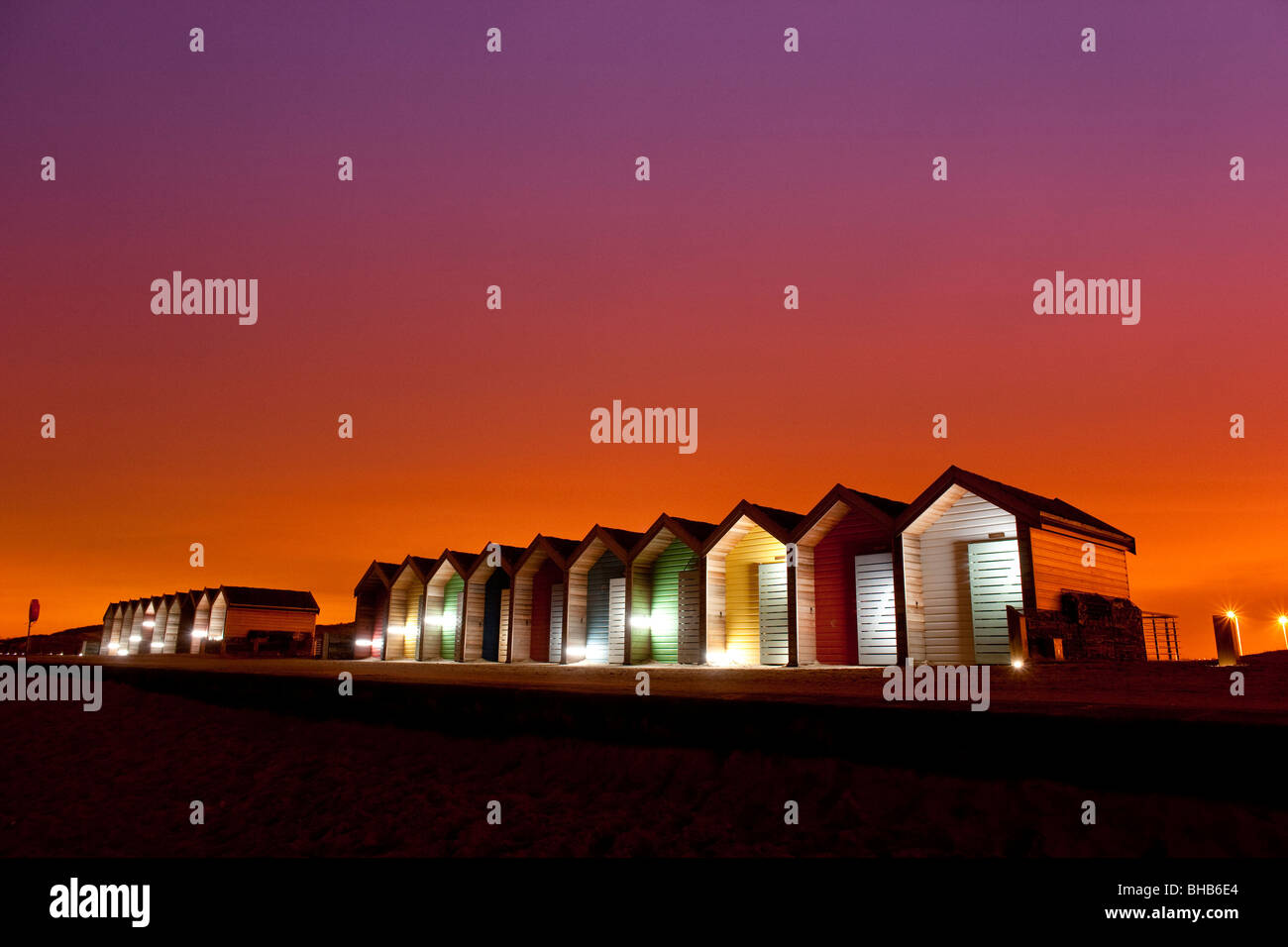 Colourful, illuminated beach huts at sunset on Blyth Beach ...