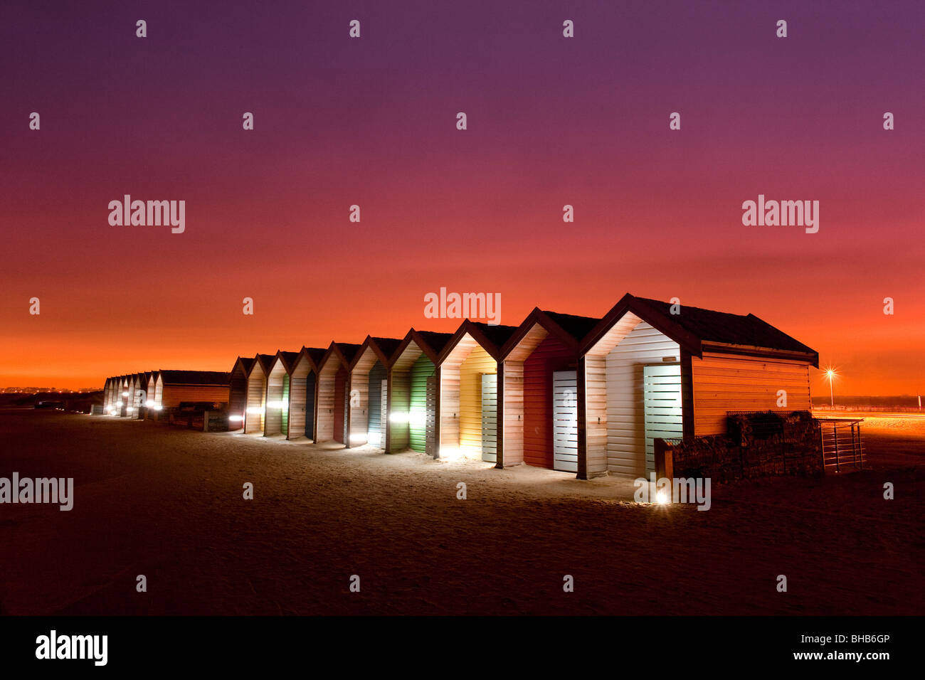 Colourful, illuminated beach huts at sunset on Blyth Beach ...