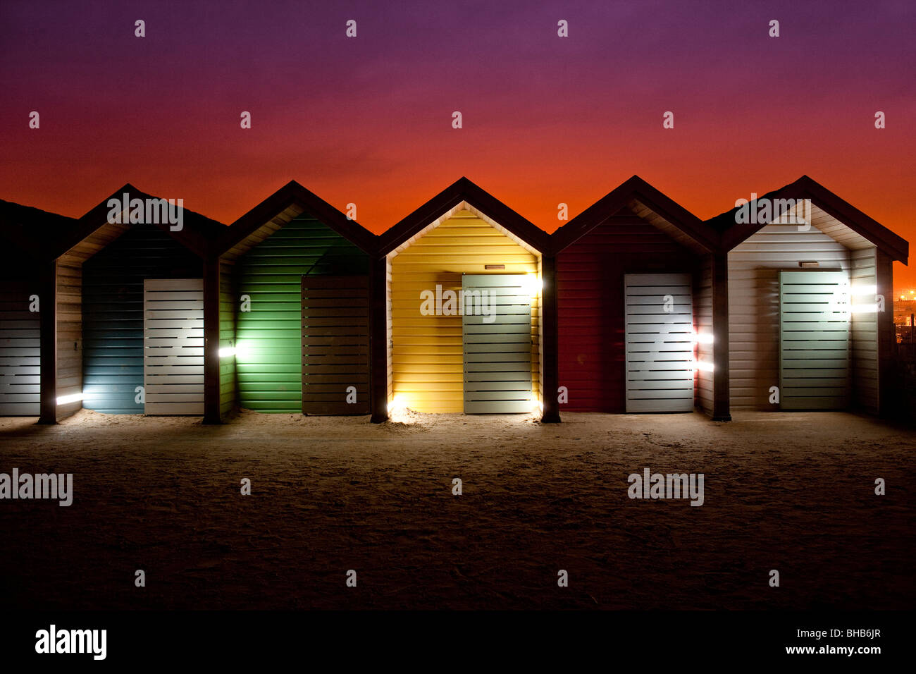Colourful, illuminated beach huts at sunset on Blyth Beach ...