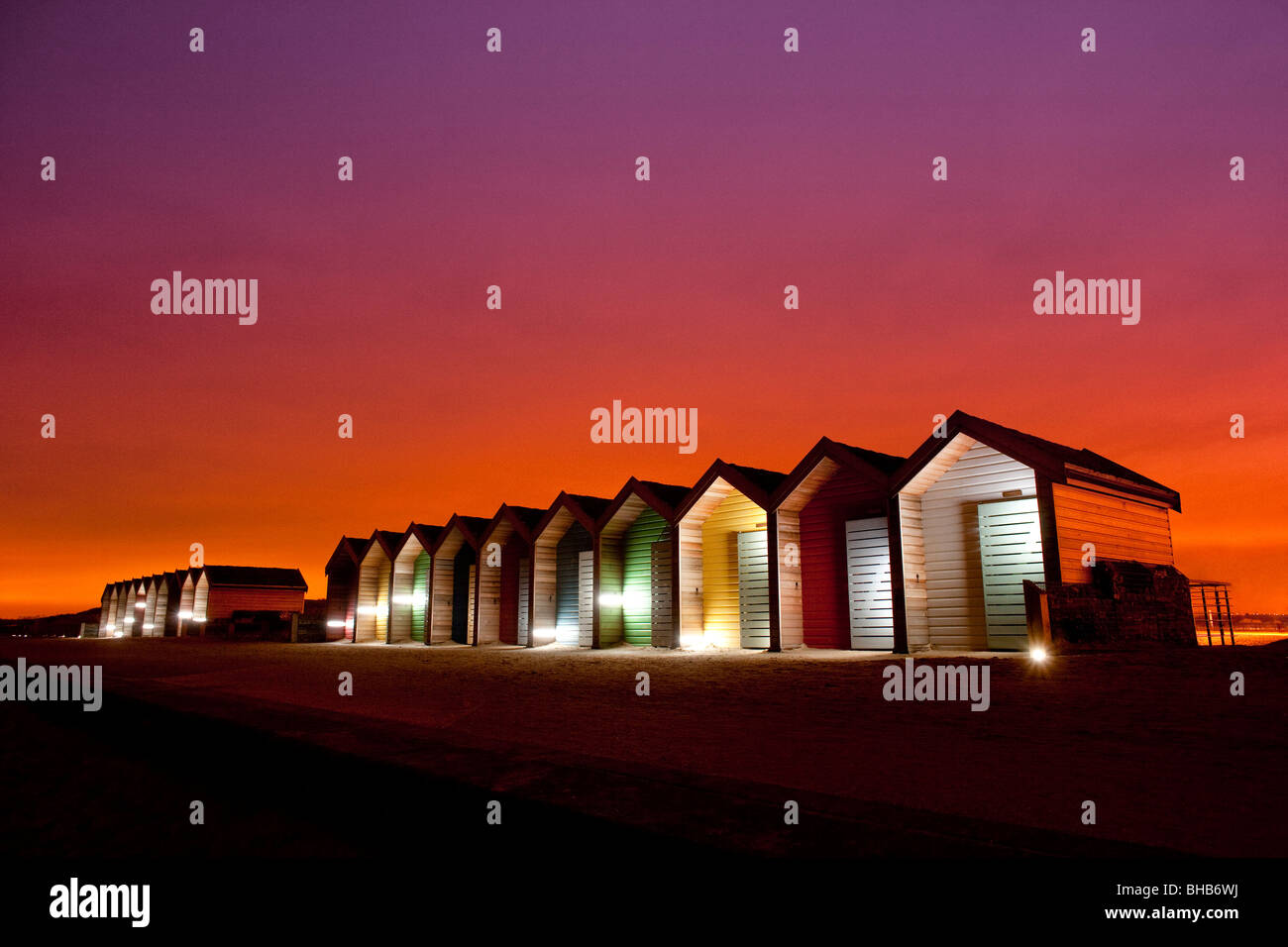Colourful, illuminated beach huts at sunset on Blyth Beach ...