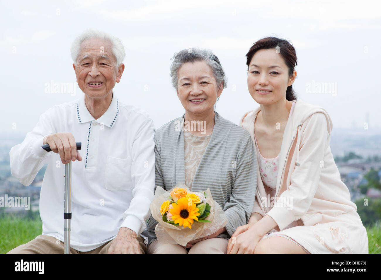 Japan, Tokyo Prefecture, Young woman sitting with parents, smiling ...