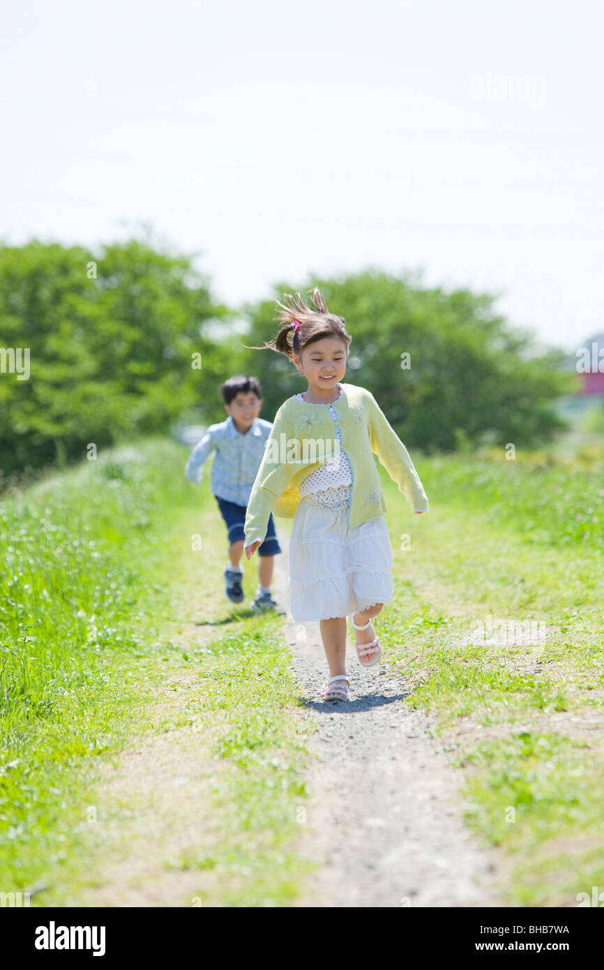 Japan, Tokyo Prefecture, Children running through dirt track Stock ...