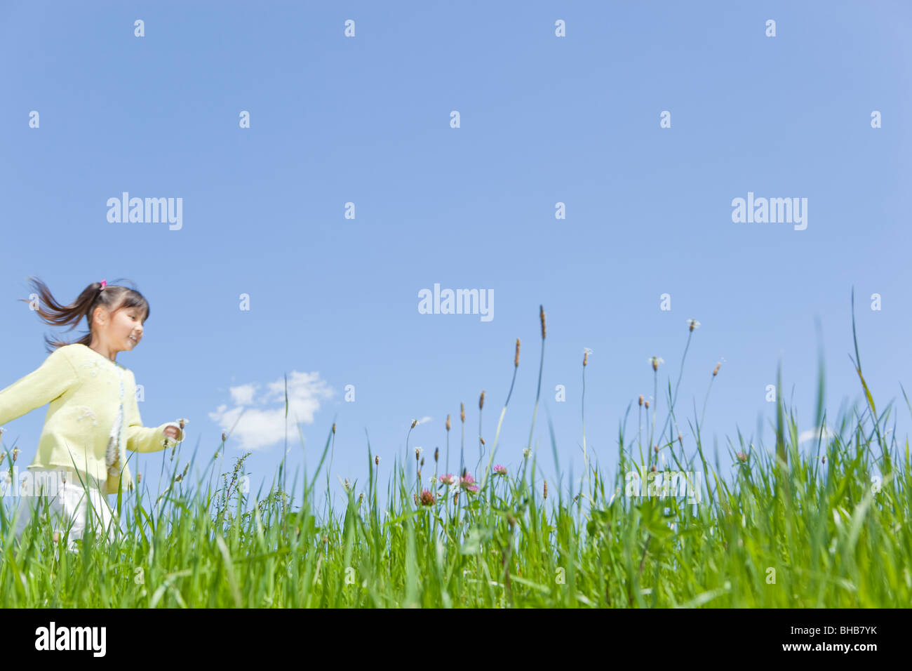 Japan, Tokyo Prefecture, Girl running in meadow, side view Stock Photo ...