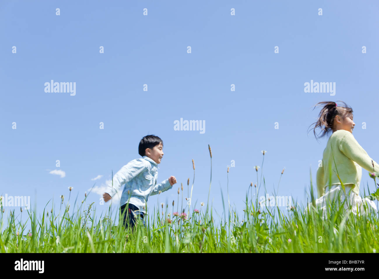 Japan, Tokyo Prefecture, Children running in meadow, side view Stock ...