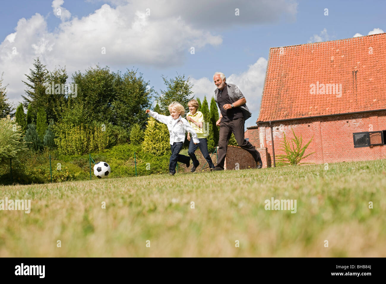 grandfather and kids playing football Stock Photo - Alamy