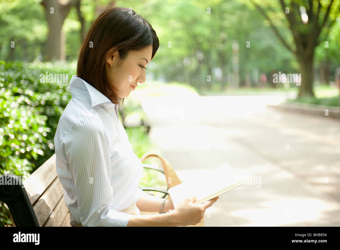 Japan, Osaka Prefecture, Businesswoman sitting, reading diary, side ...
