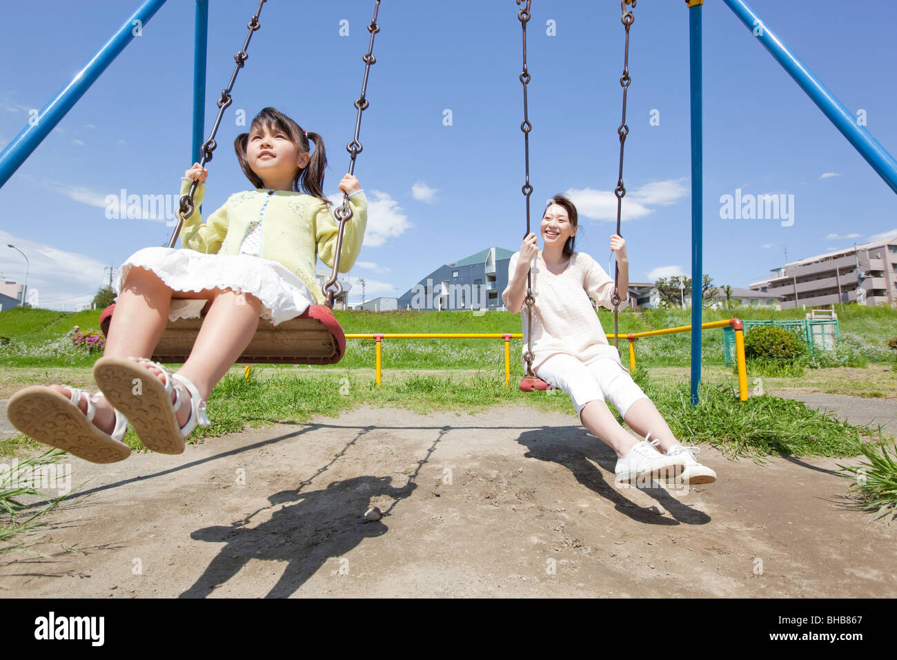 Japan, Tokyo Prefecture, Mother and daughter swinging in park, smiling Stock Photo - Alamy