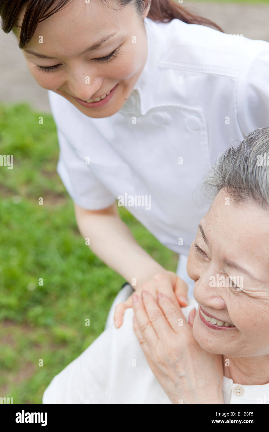 Japan, Tokyo Prefecture, Female nurse consoling senior woman, close-up ...