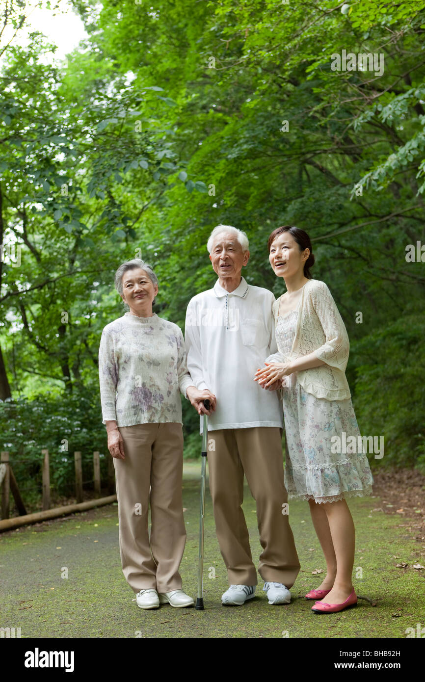 Japan, Tokyo Prefecture, Young woman with parents standing in park ...