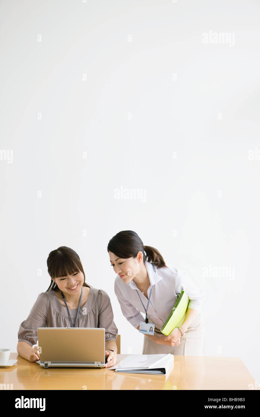 Japan, Osaka Prefecture, Businesswomen using laptop, smiling Stock ...