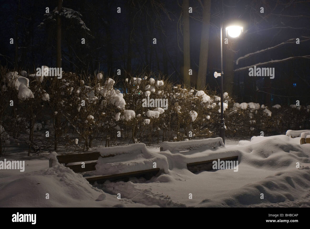 Two benches covered with snow under a lantern Stock Photo - Alamy