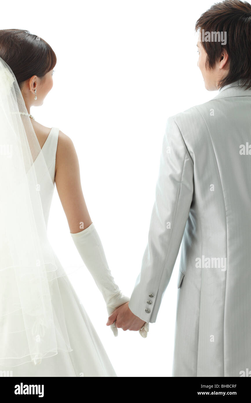 bride and groom holding hands, rear view Stock Photo - Alamy