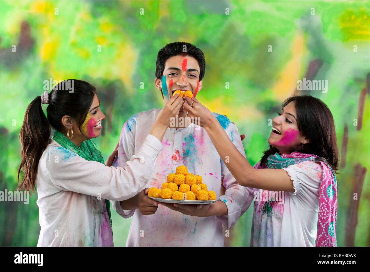 Women feeding a man laddoos Stock Photo - Alamy