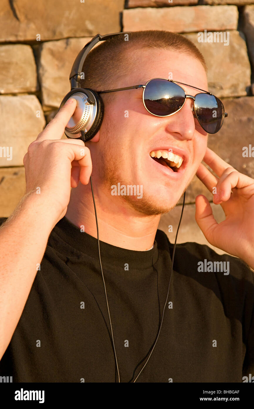 A young man listens to music on his mp3 player Stock Photo - Alamy