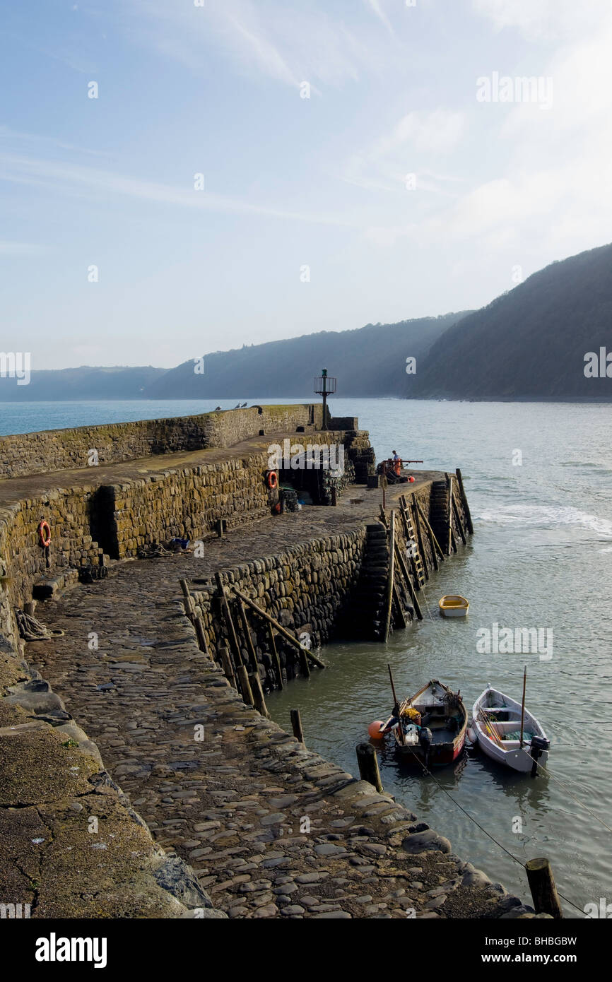 Clovelly quay harbor & sea wall & lone fisherman mending nets & pots ...