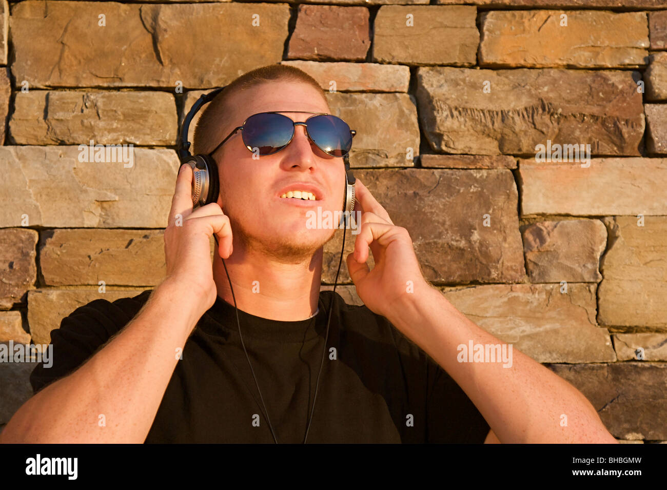 A young man listens to music on his mp3 player Stock Photo - Alamy