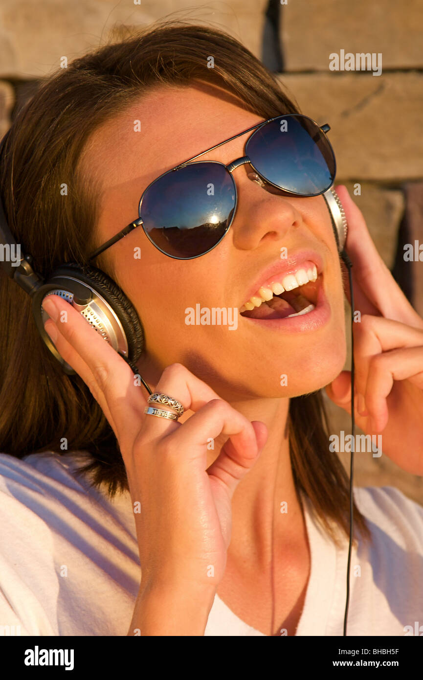 A beautiful young woman listens to hear music on her headphones Stock ...
