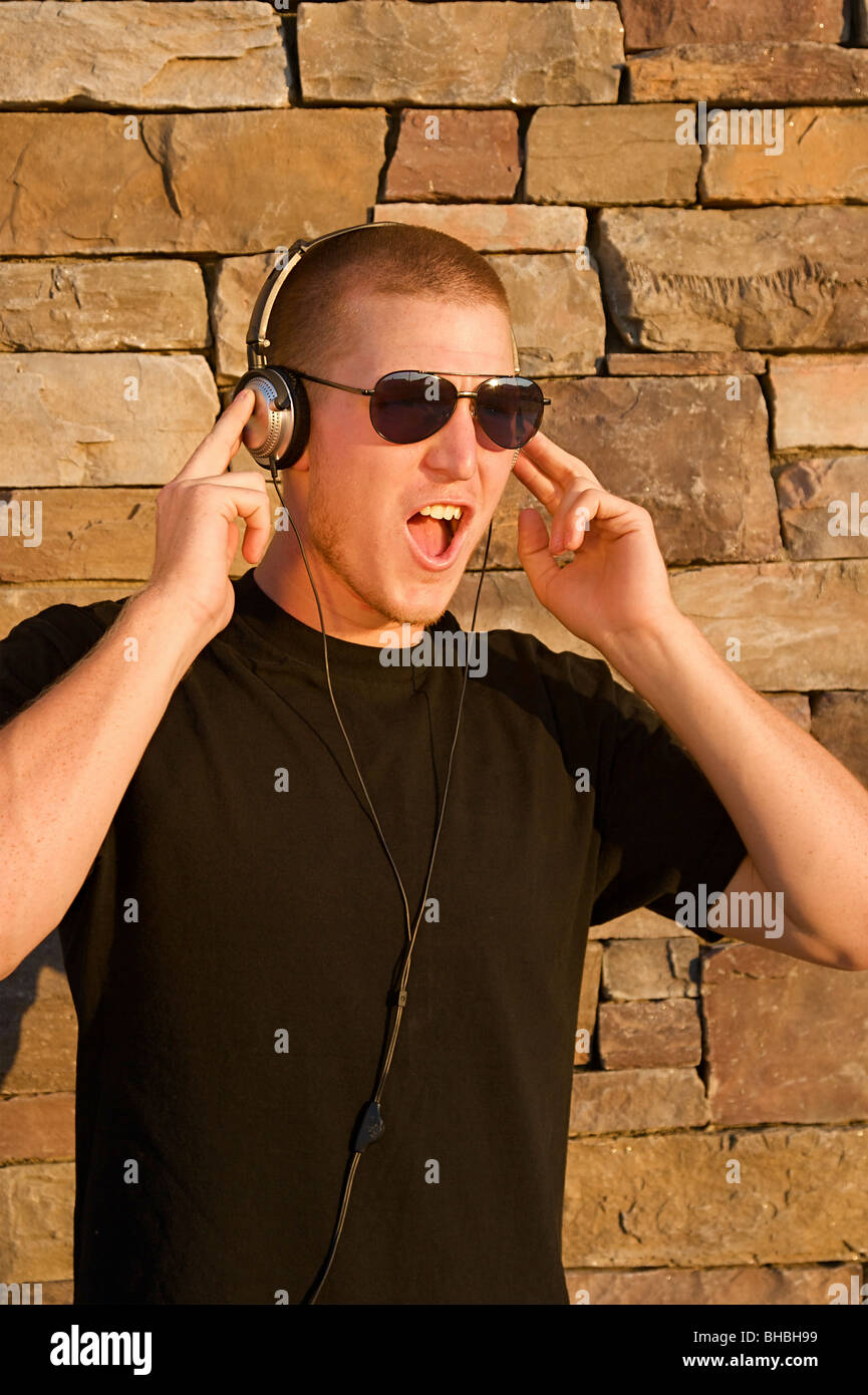 A young man listens to music on his mp3 player Stock Photo - Alamy