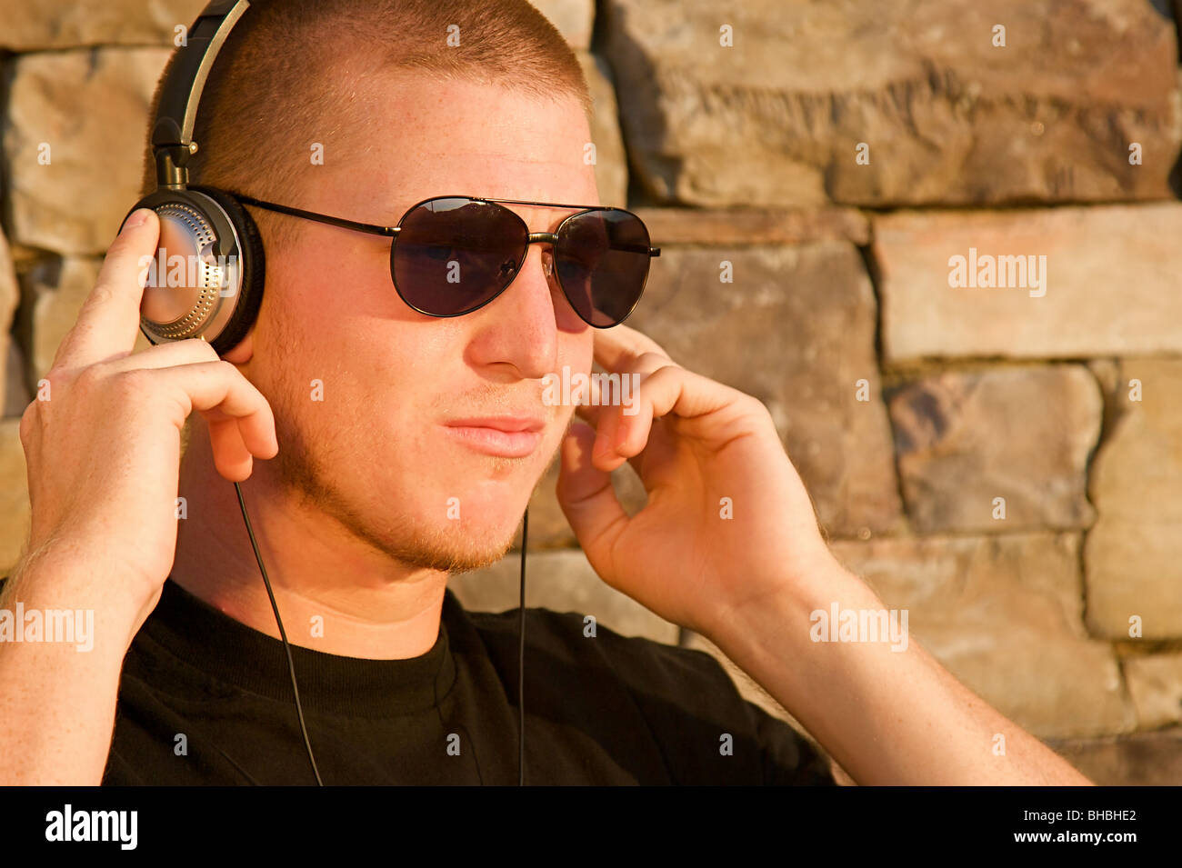 A young man listens to music on his mp3 player Stock Photo - Alamy