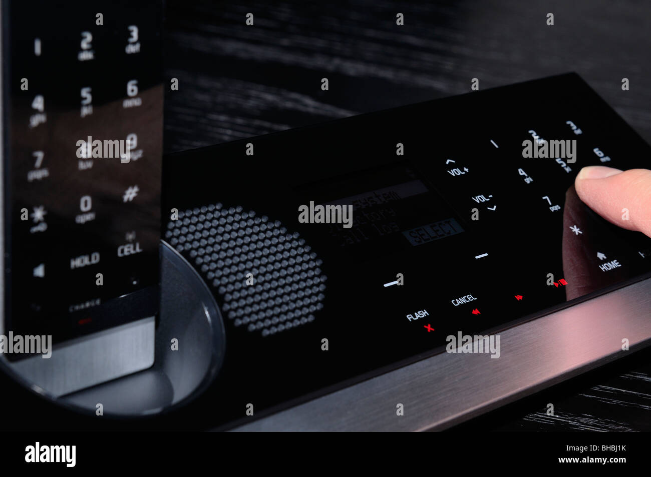 Dialing a number on a sleek glass telephone on a black oak table Stock ...