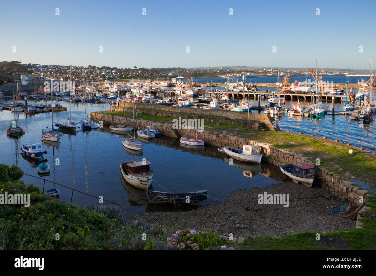 The last of the evening sunlight catching the old harbour wall at ...