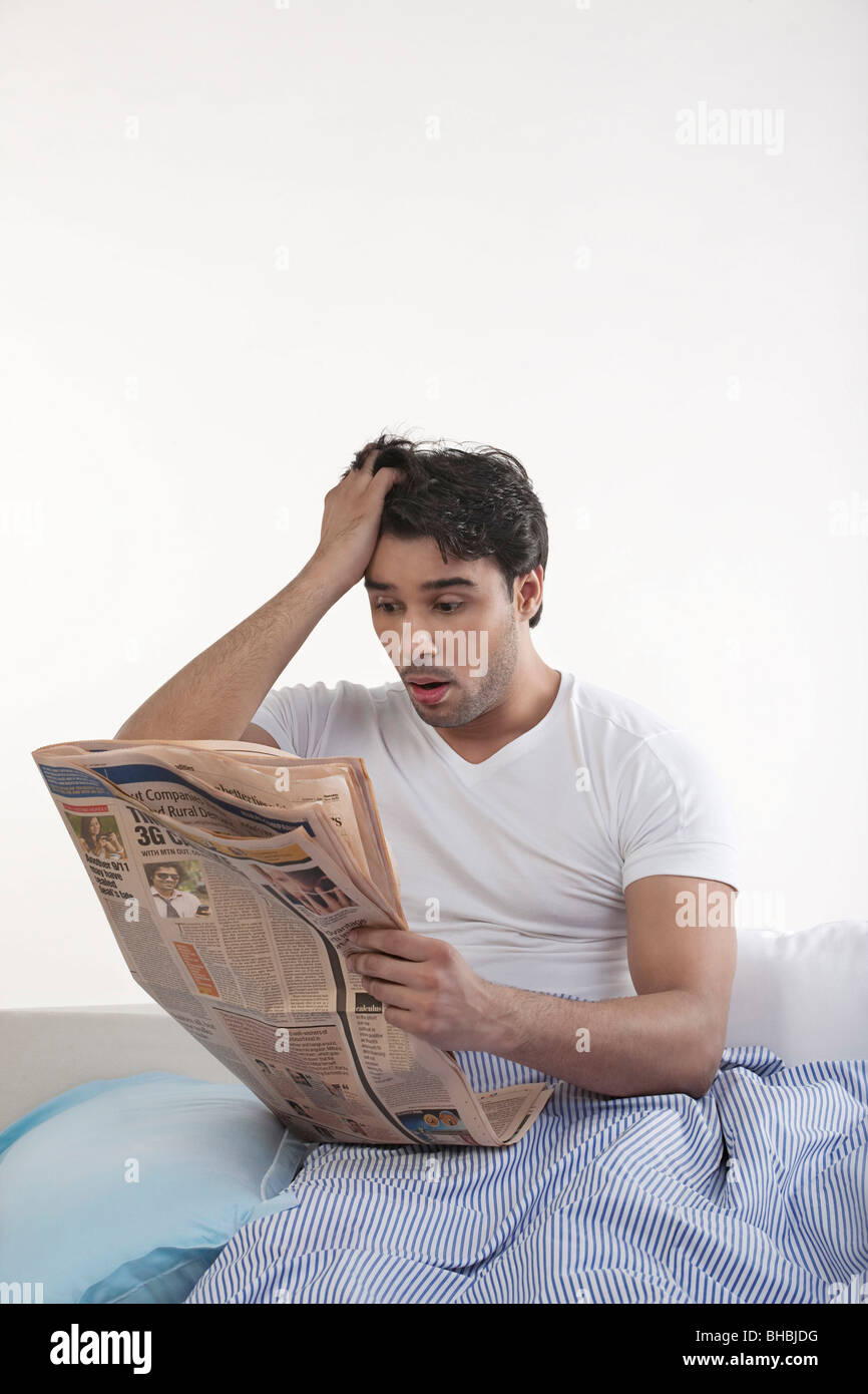 Man shocked after reading newspaper Stock Photo - Alamy