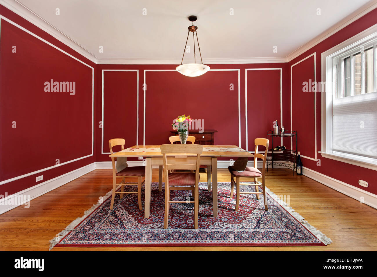 Dining room in condo with red walls Stock Photo - Alamy
