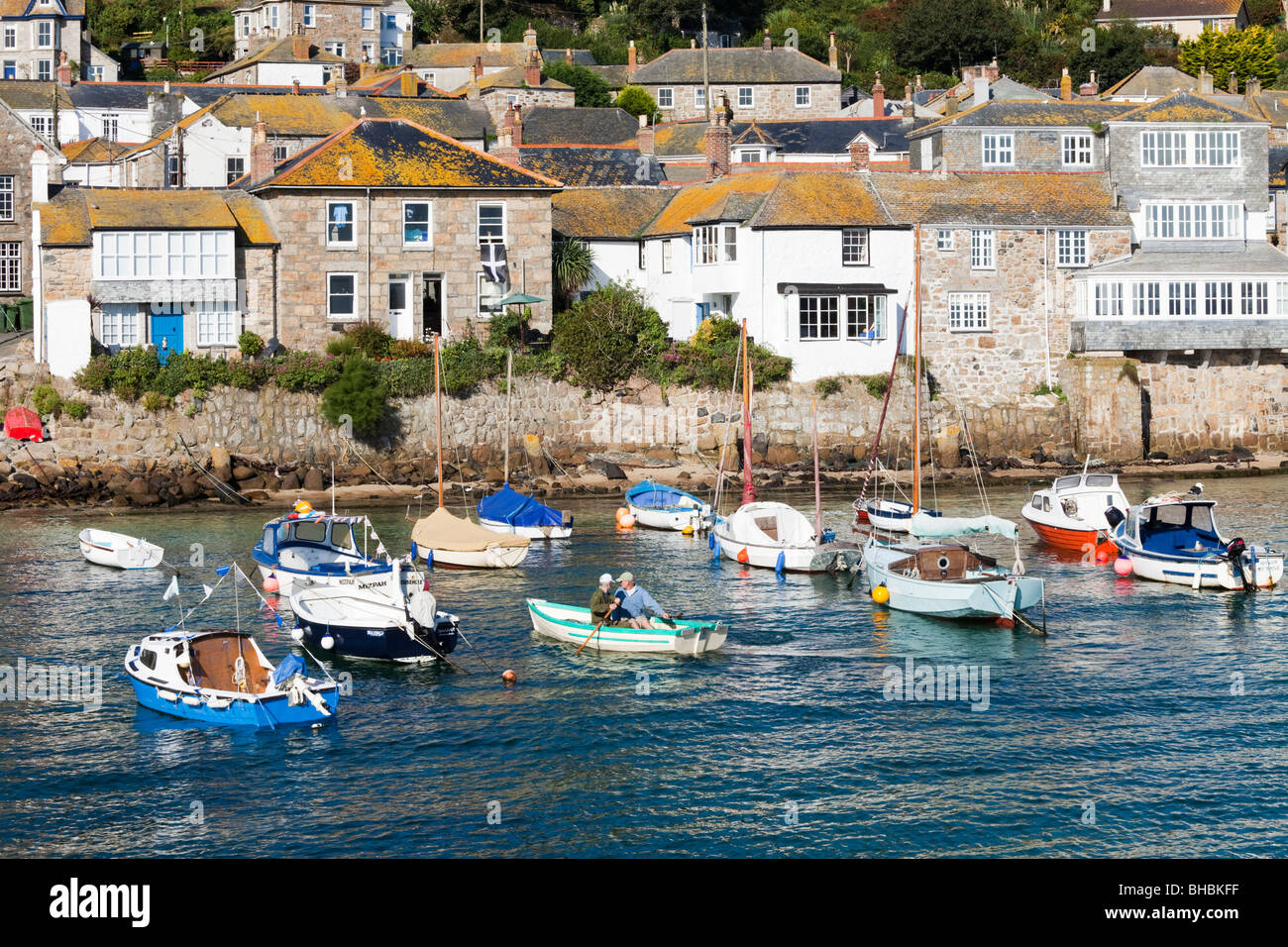 Rowing across the harbour in the old fishing village of Mousehole ...