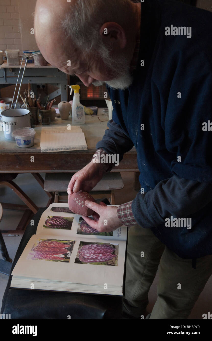 Kelso Pottery, Scotland, UK - potter Ian Hird at work, studying photos ...