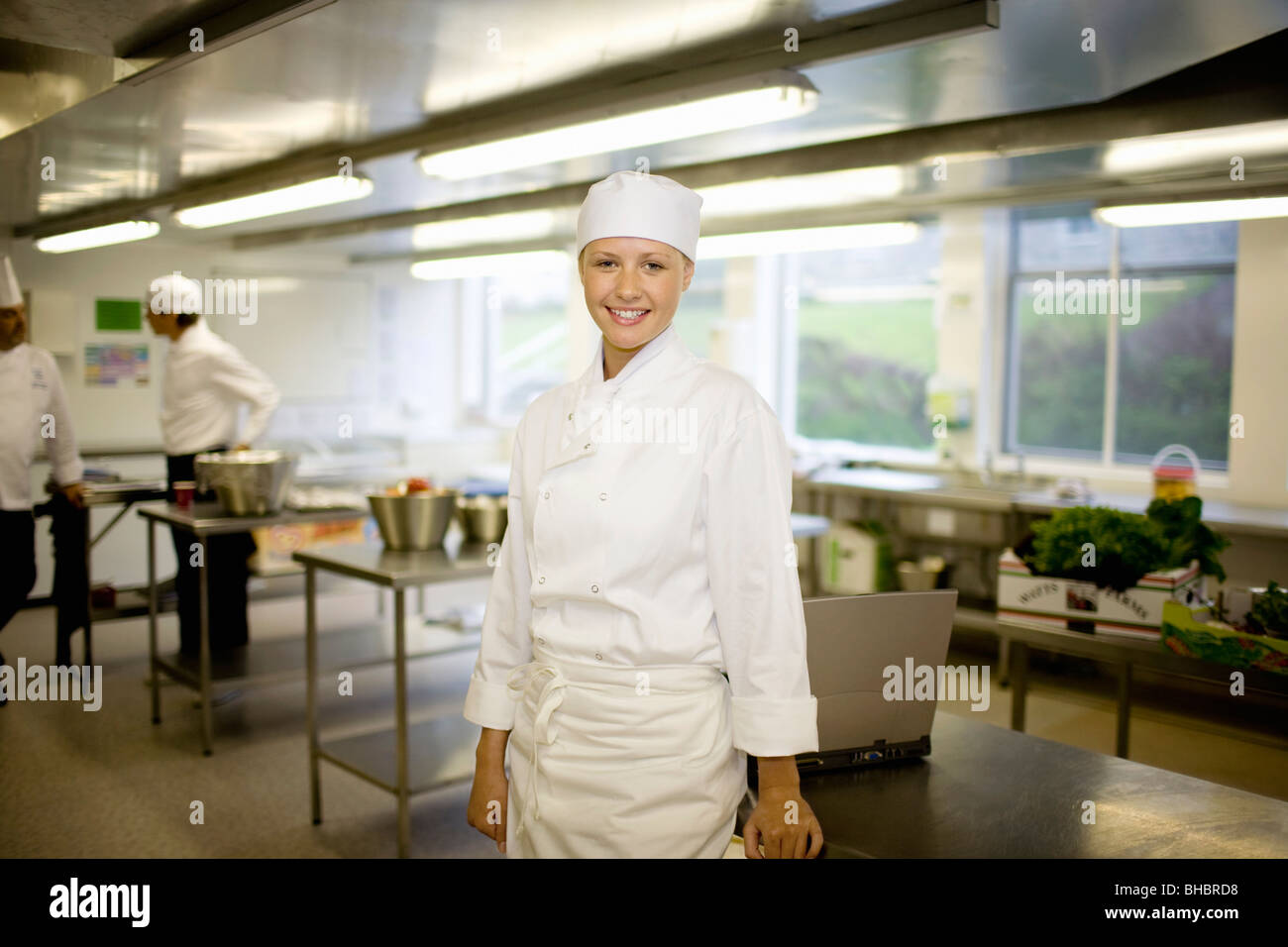 Portrait of a smiling female cook standing in the kitchen Stock Photo ...