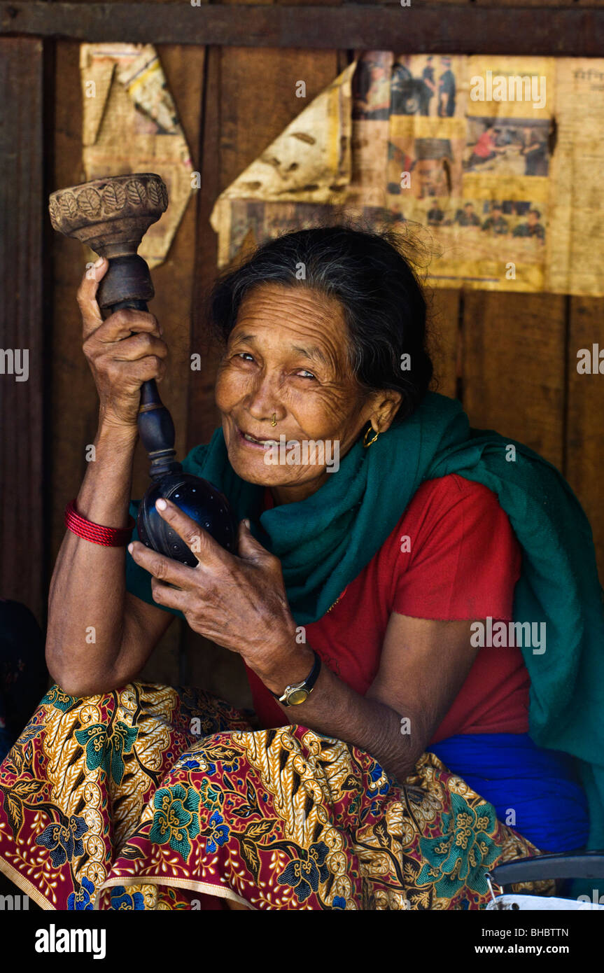 A NEPALI VILLAGE WOMAN smokes tobacco in a HOOKAH PIPE - AROUND MANASLU ...