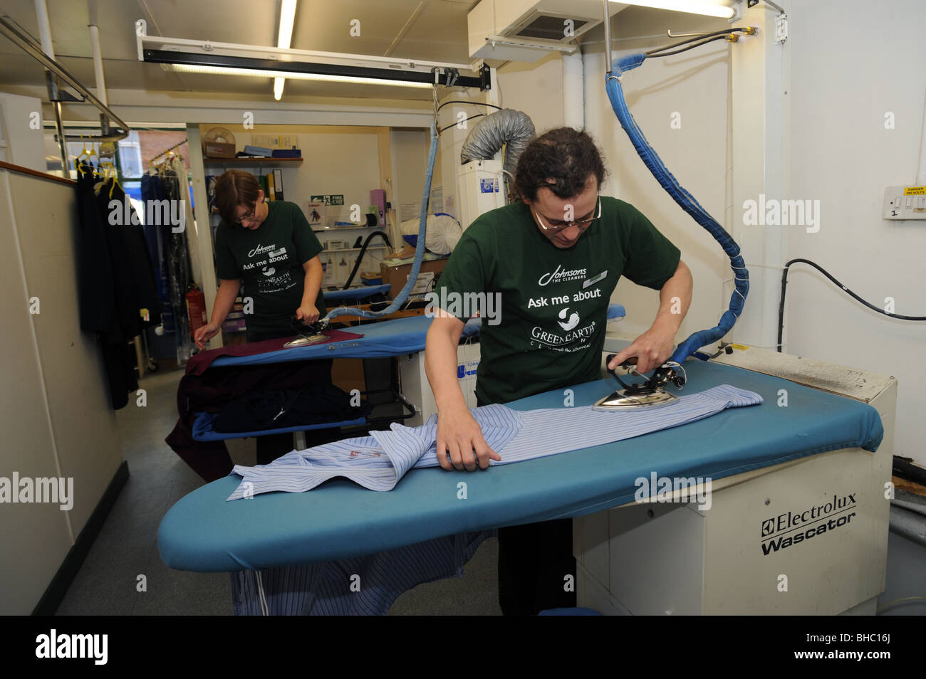 Two people ironing clothes in a branch of Johnsons the cleaners Stock ...