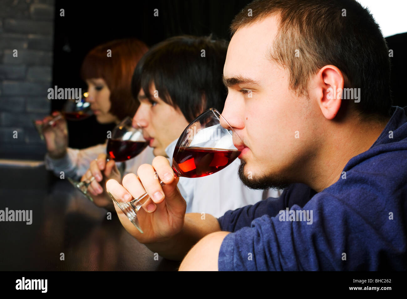 Young people drinking red wine on a bar counter Stock Photo - Alamy