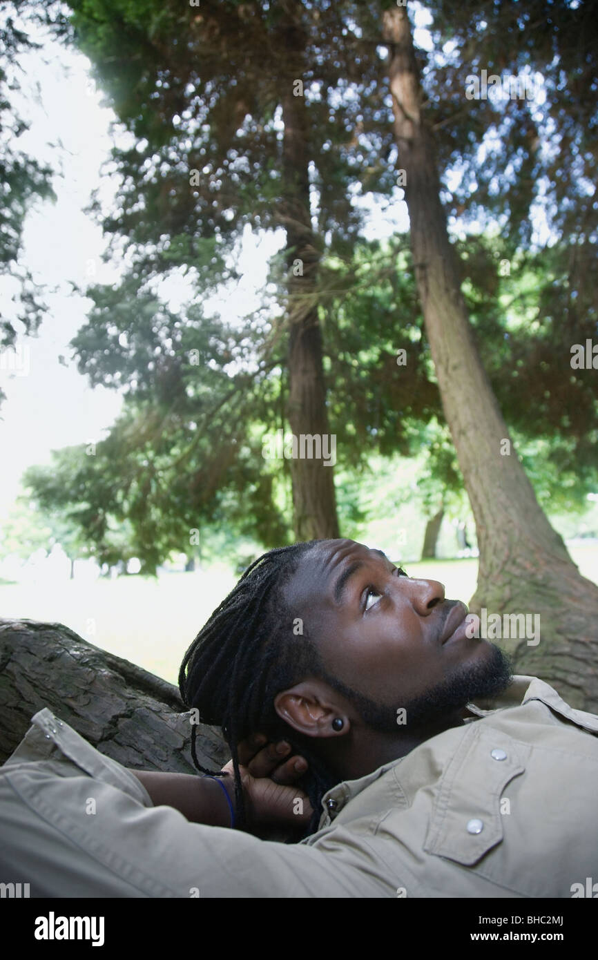 Close up of African man laying in forest Stock Photo - Alamy