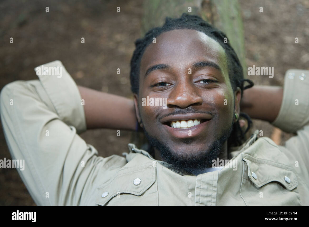 Portrait of African man laying on ground Stock Photo - Alamy