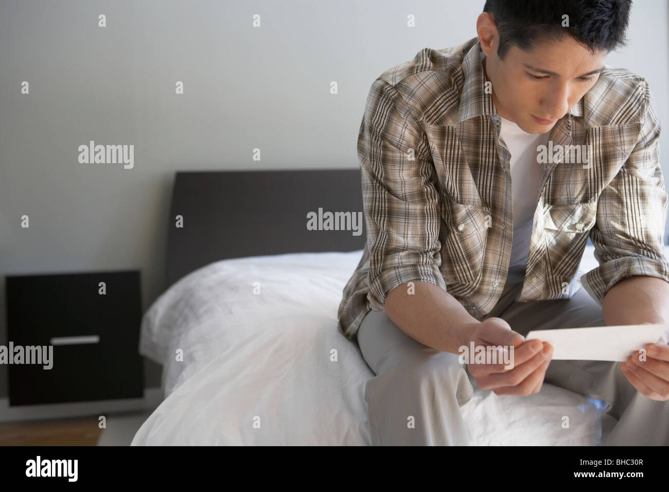 Asian man looking at photograph Stock Photo - Alamy