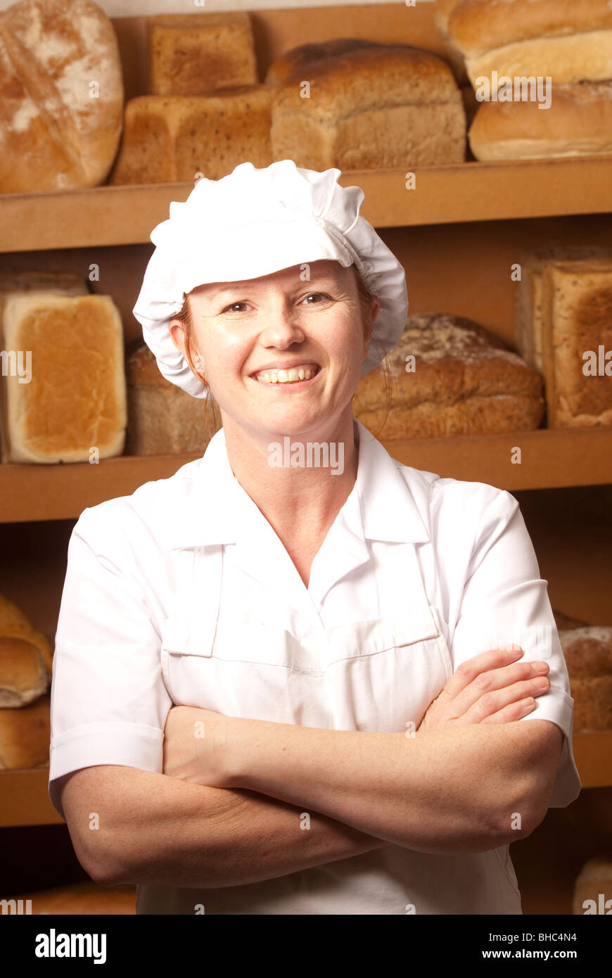 Female baker stand with arms folded in front of bread Stock Photo - Alamy