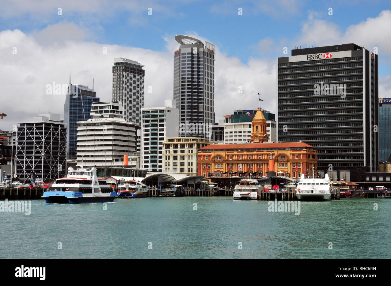 The historic Old Ferry Building at Auckland harbour, dwarfed by modern ...